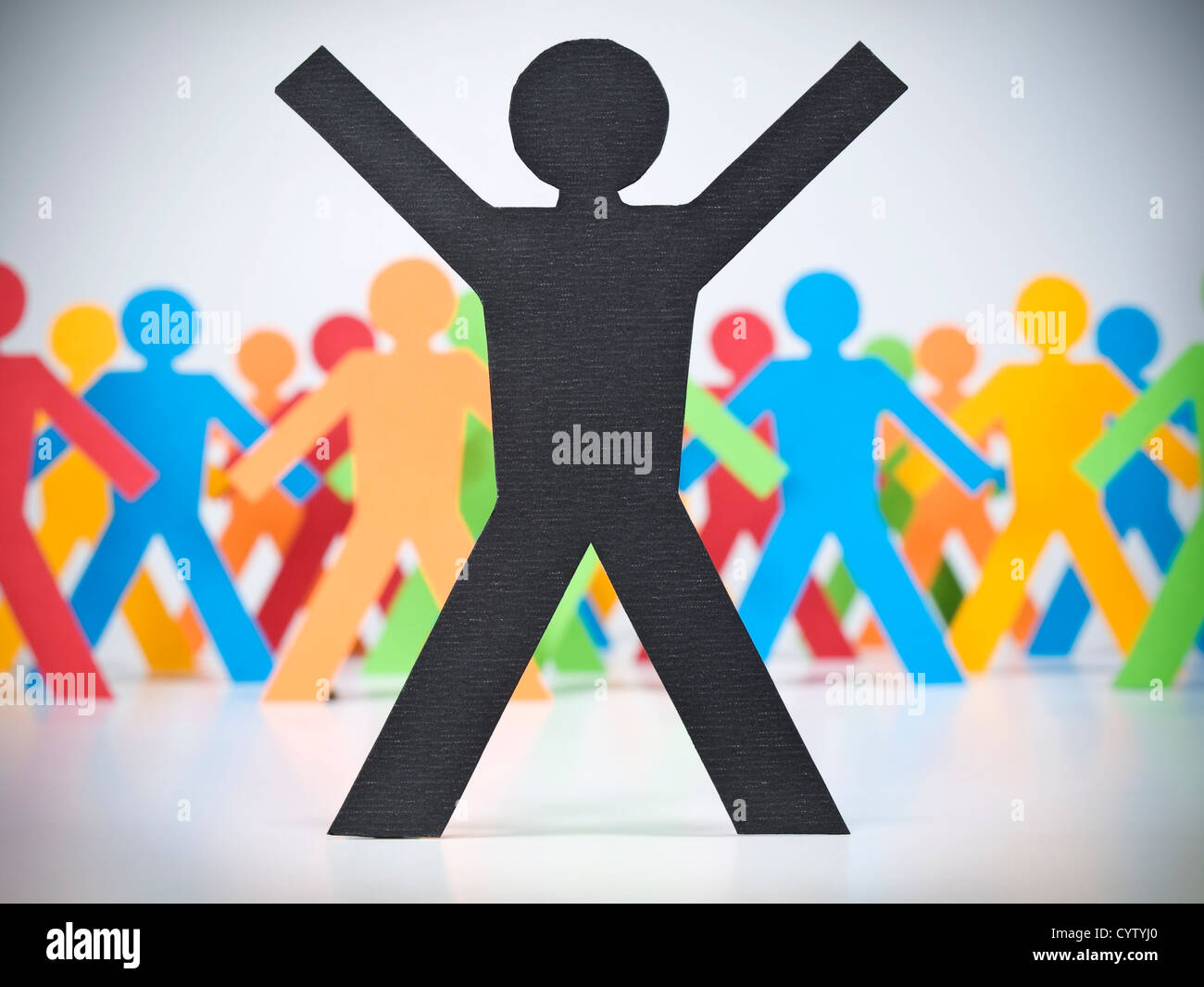 A black paper figure stands out from the crowd. Selective focus on the ...