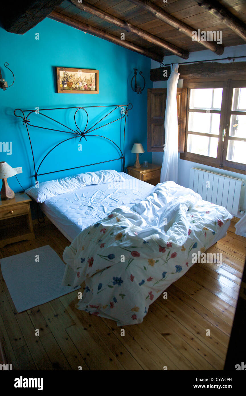 bed at a lonely bedroom with blue wall Stock Photo - Alamy