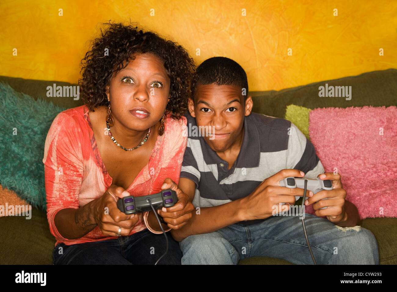 Good-looking mom and son Playing a Video Game with Handheld Controllers ...