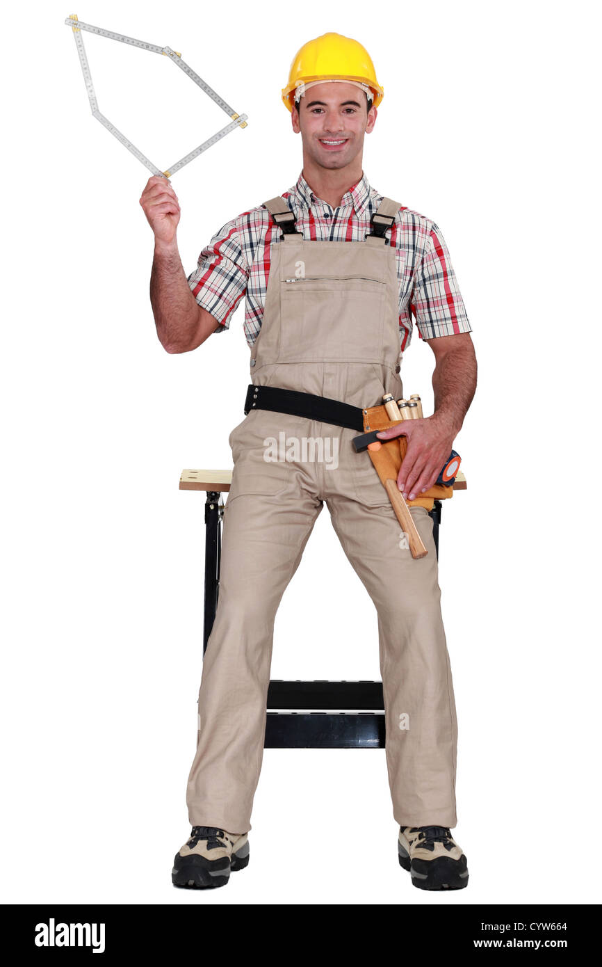carpenter holding rule shaped as house Stock Photo - Alamy