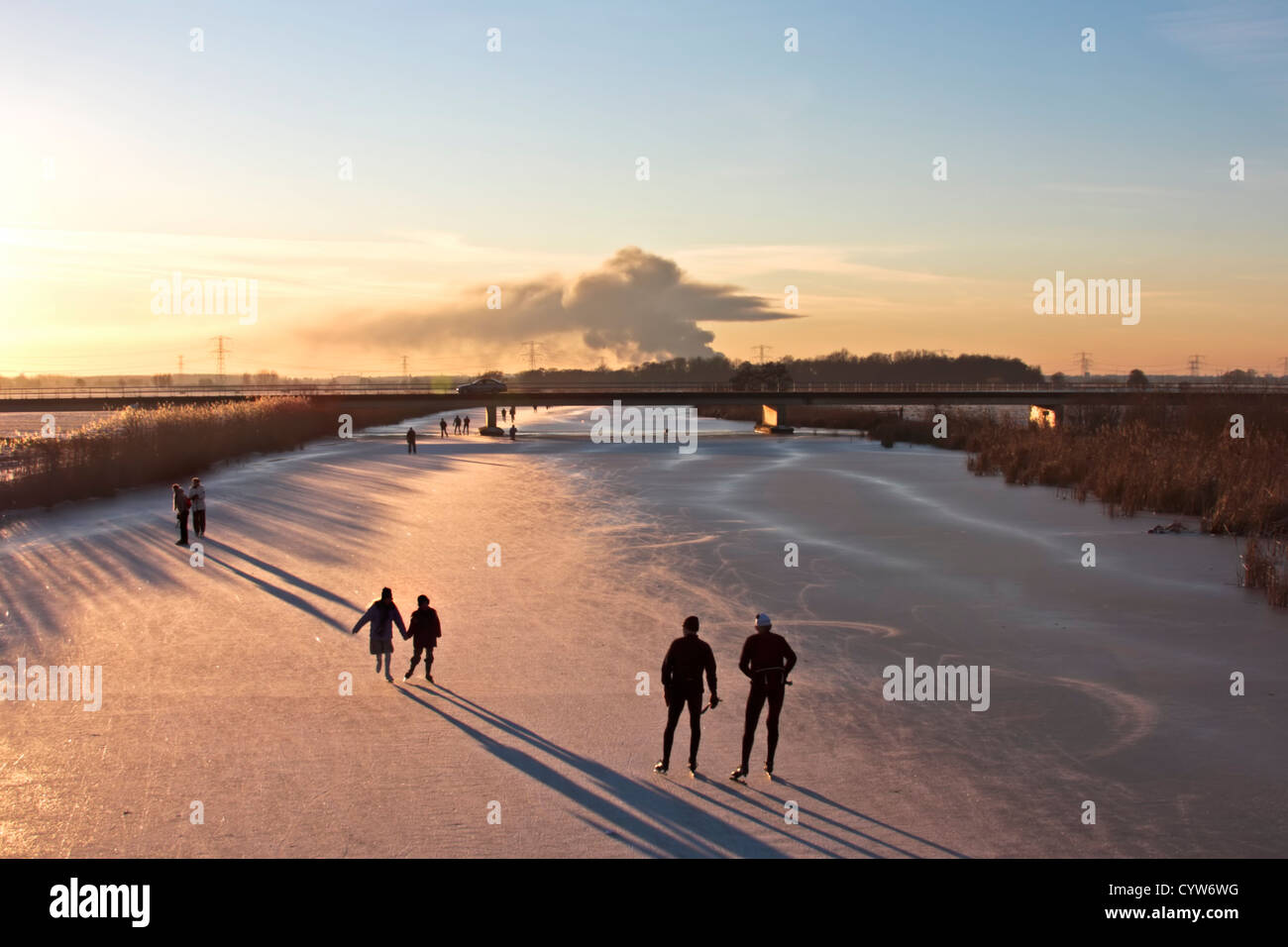 Typically dutch: ice skating on a frozen lake on a cold winterday in ...