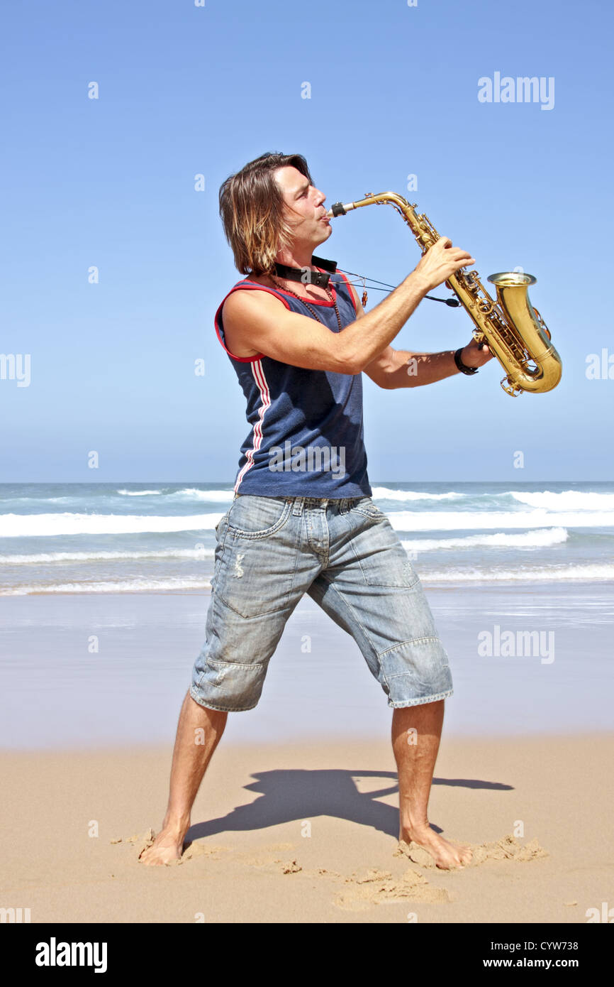 Saxophone player playing at the beach Stock Photo - Alamy