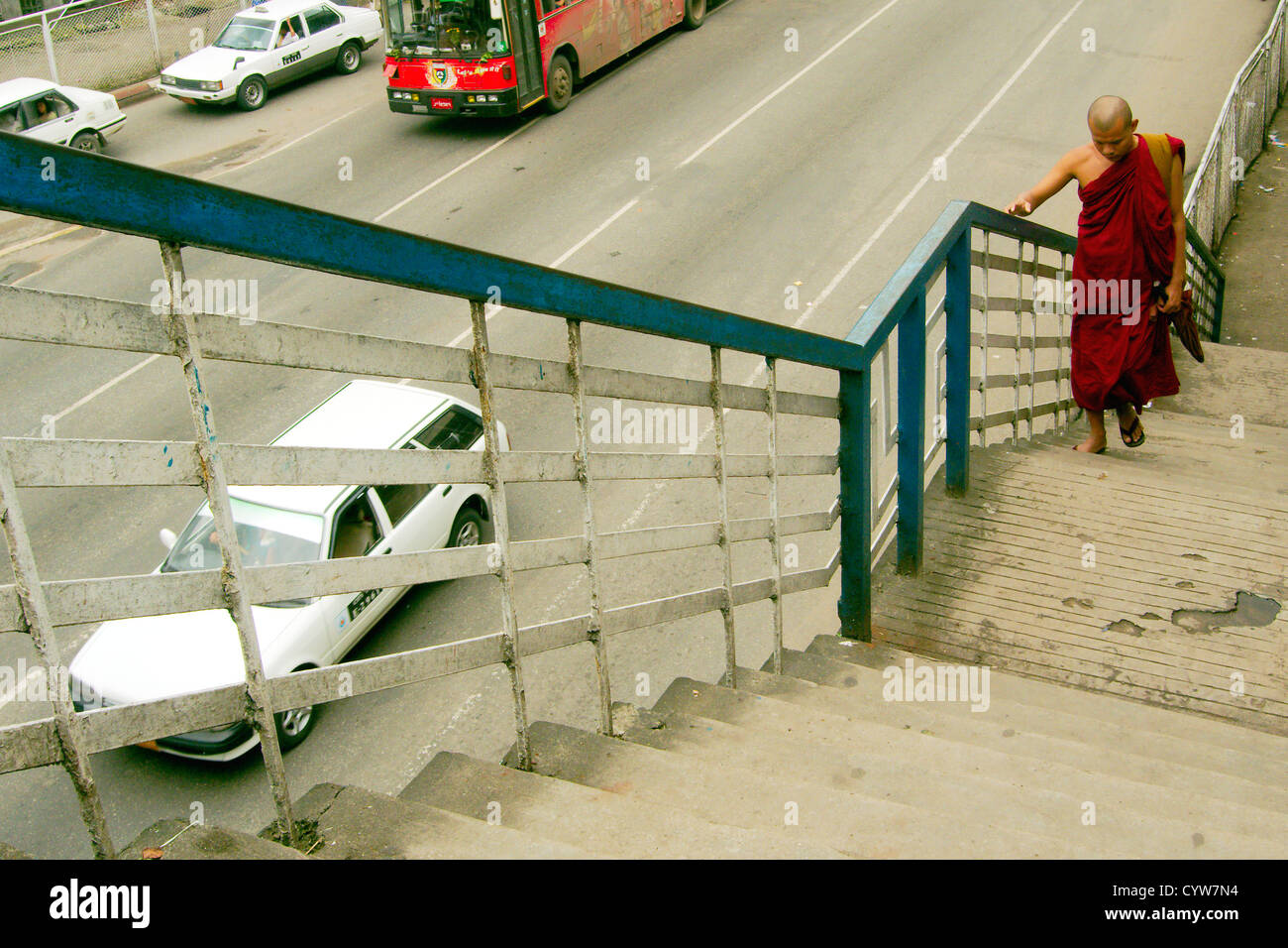 Monk climbing the stairs of a pedestrian passage at yangon Stock Photo ...