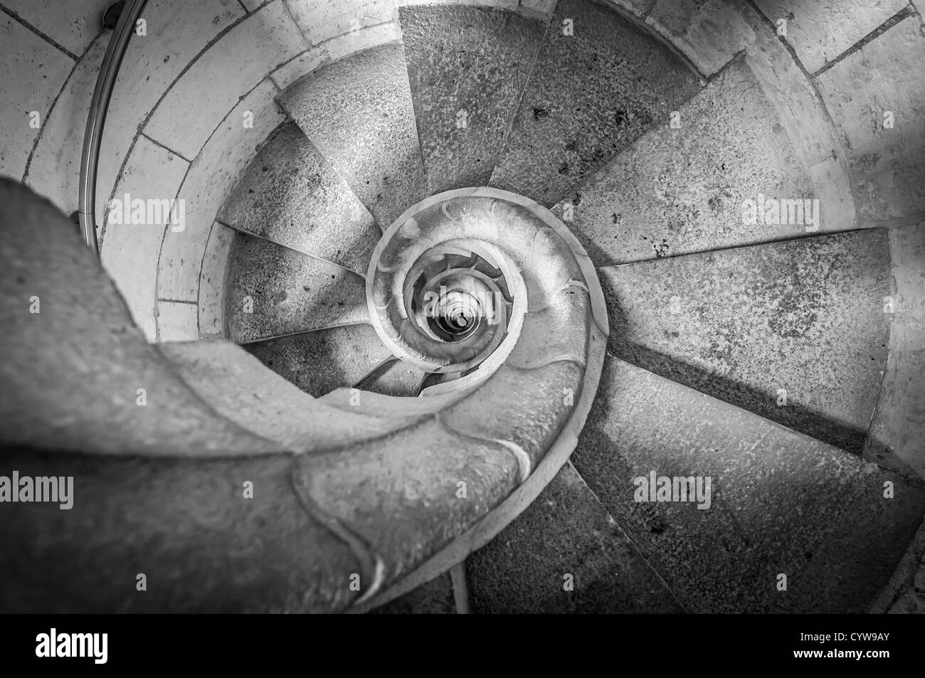 Spiral staircase vanishing downstairs. Stone steps and walls of tower ...