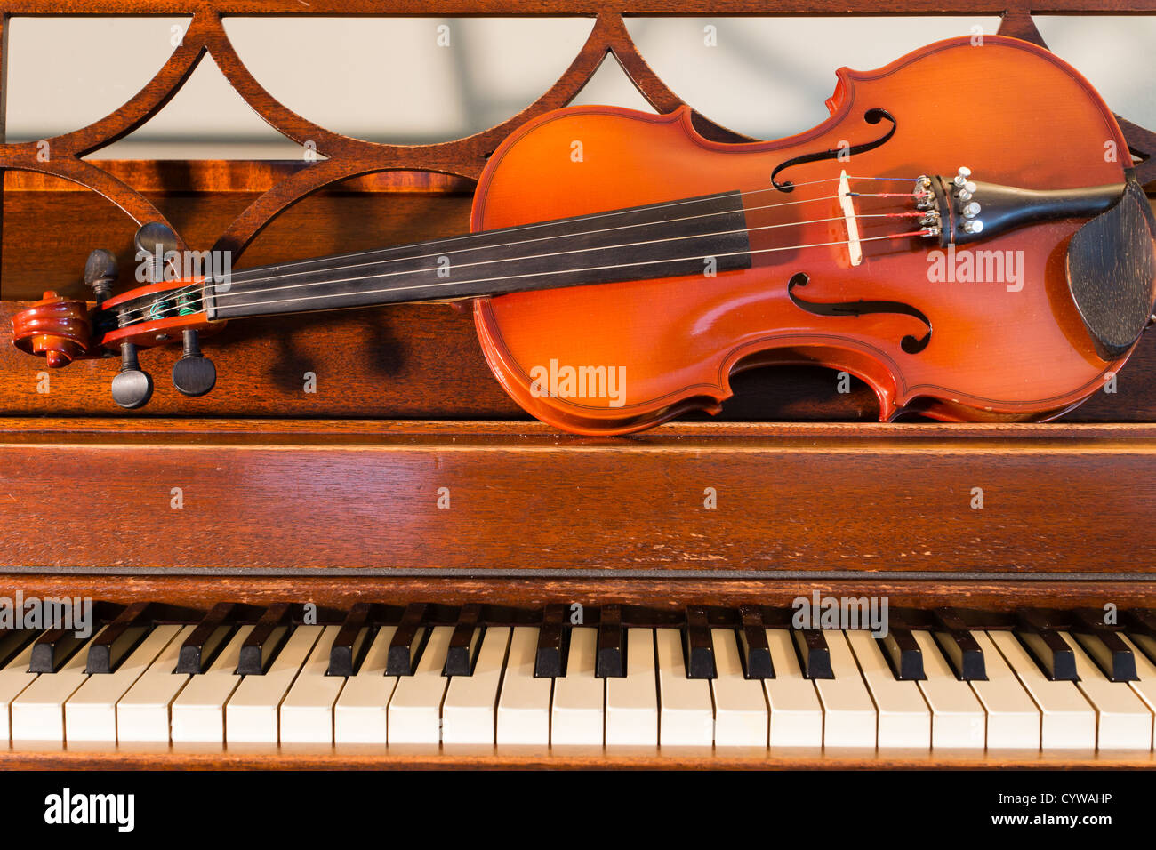 A violin rests on an old upright piano Stock Photo - Alamy