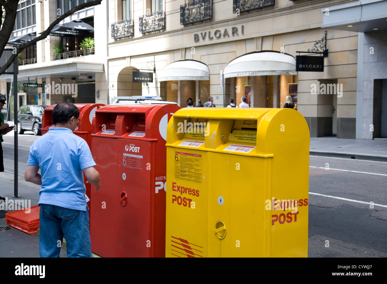 asian gentleman posting a letter in one of australia post mailboxes in ...