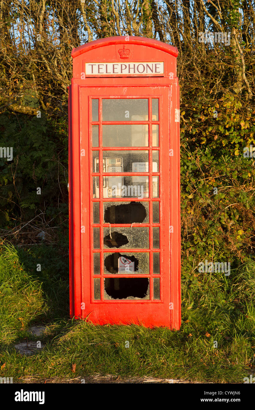 A vandalised red English phone box in the countryside Stock Photo - Alamy
