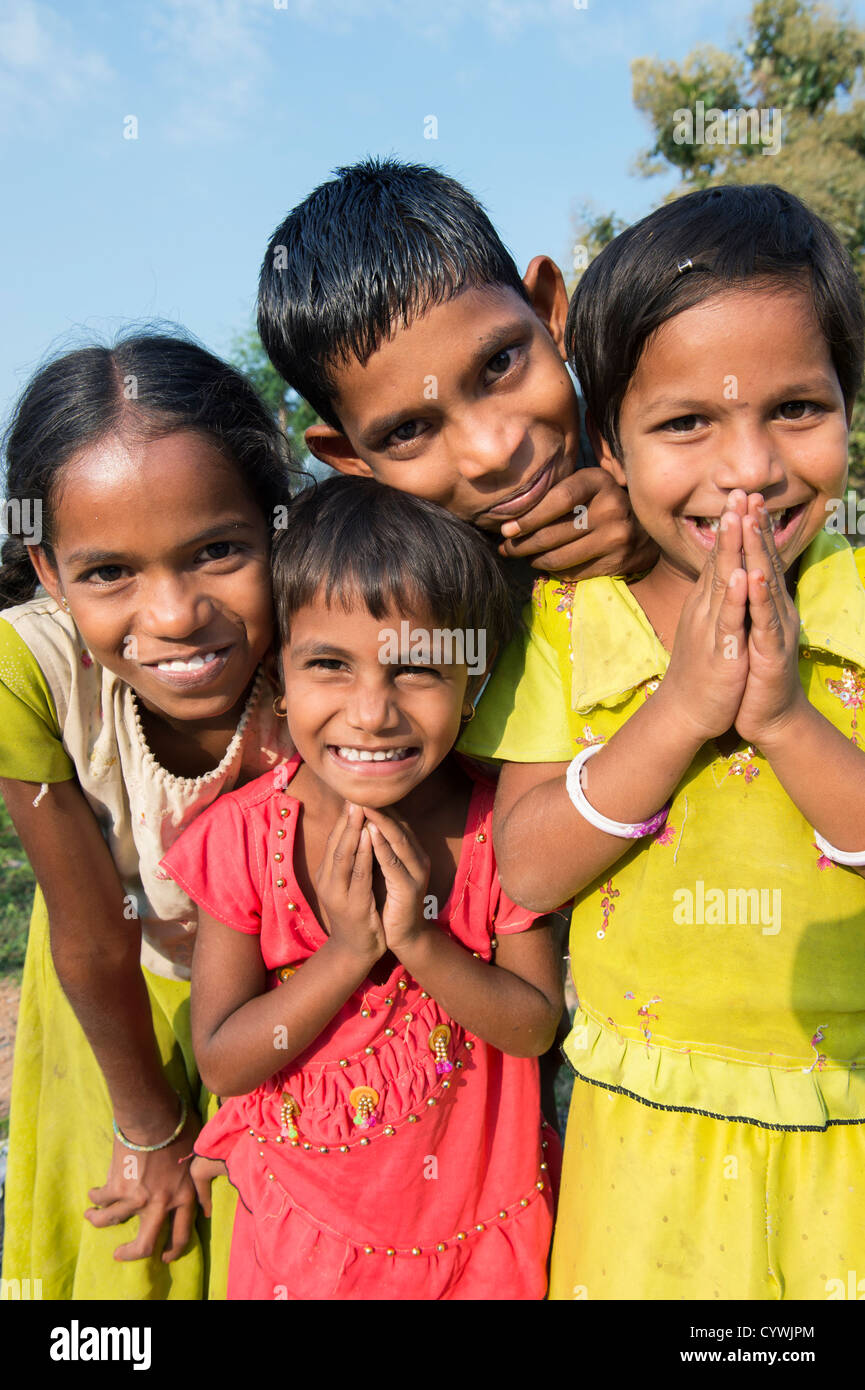 Happy young rural Indian village children sitting outside their home ...