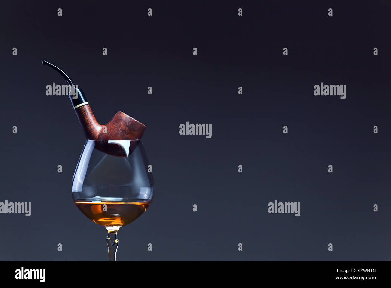 cognac and pipe on a dark background Stock Photo - Alamy