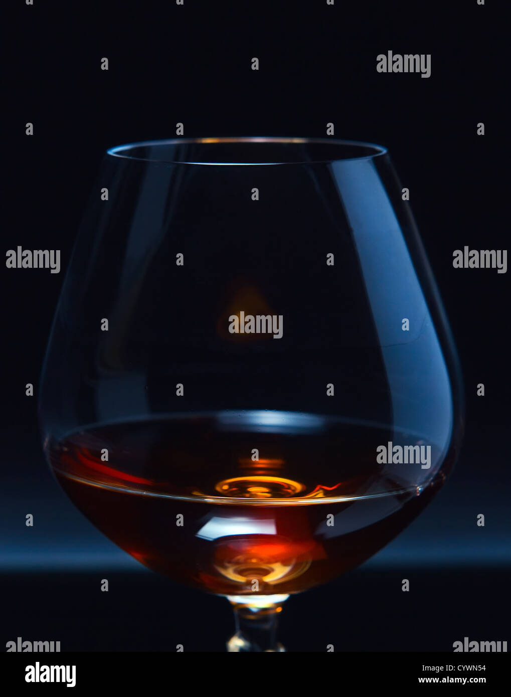 snifter with brandy on a dark background Stock Photo - Alamy