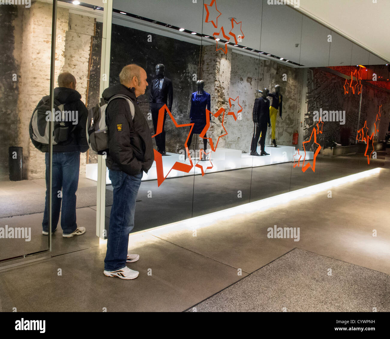 Elderly man looking at shop window display in Mitte, Berlin, Germany ...