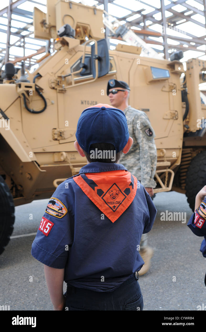 A Tiger Cub from the Boy Scouts of America watches military vehicles ...