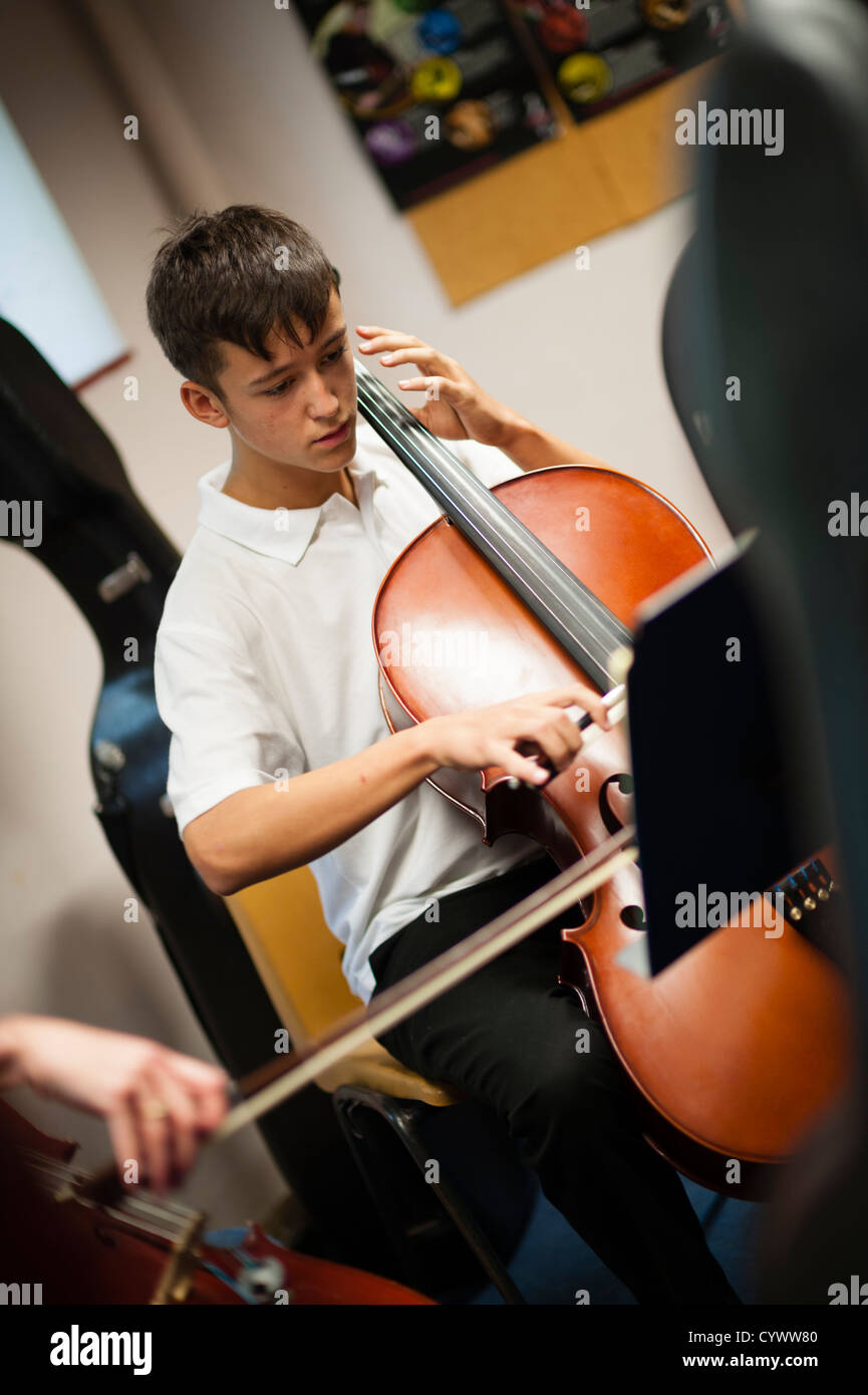 A boy playing cello music in a class at a secondary school, Wales UK ...