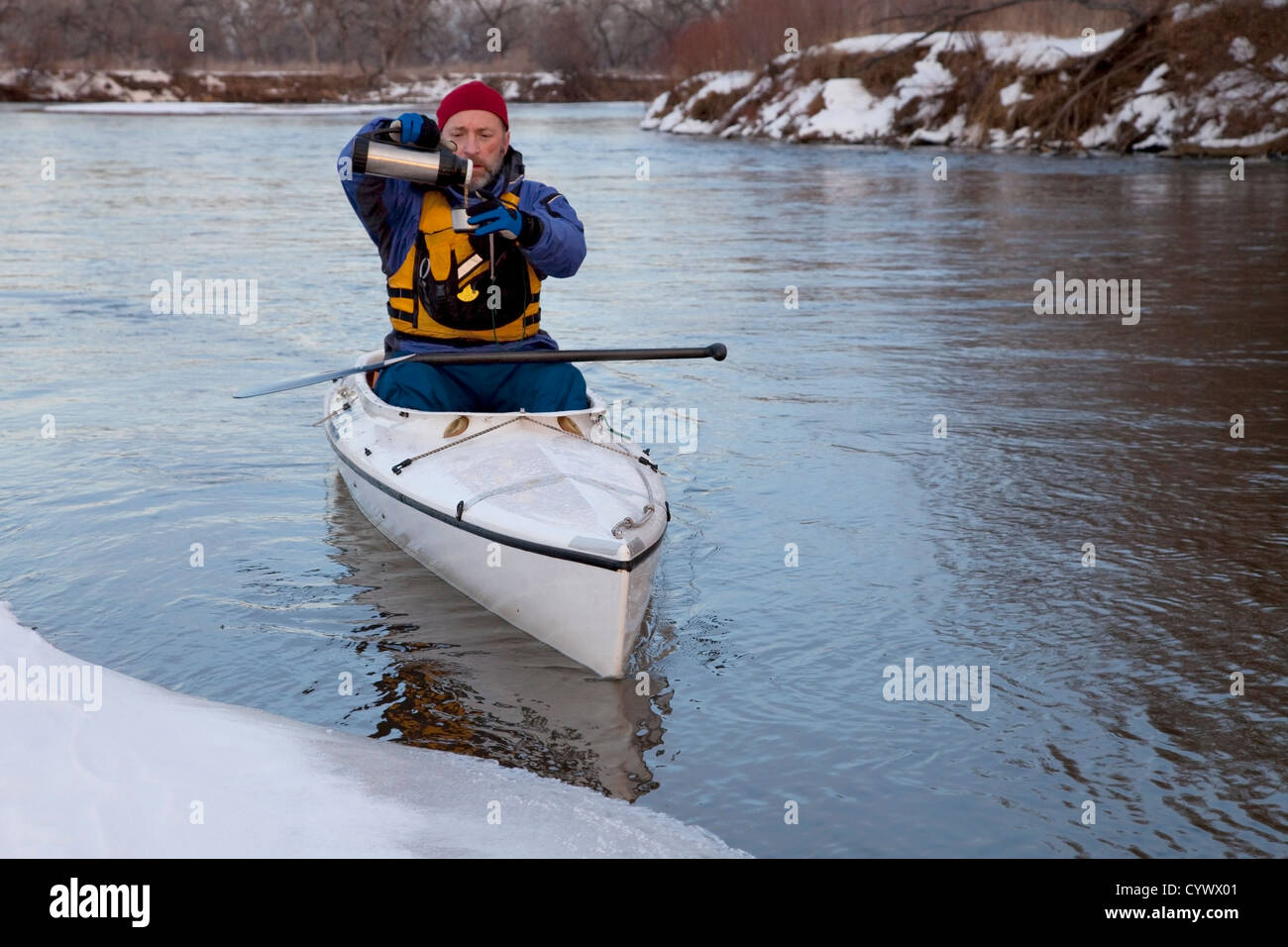 winter canoe paddling on icy river, taking a break for hot tea (South ...