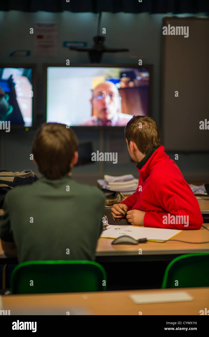 Two teenage boys getting a lesson via video conferencing at a secondary ...