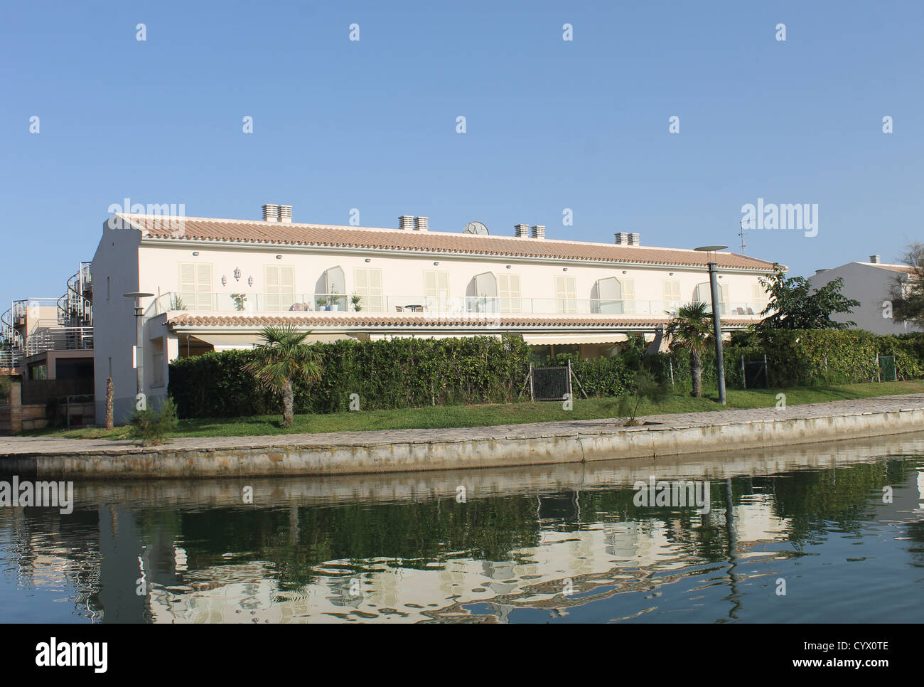 Traditional Spanish homes or apartment buildings reflecting on lake ...