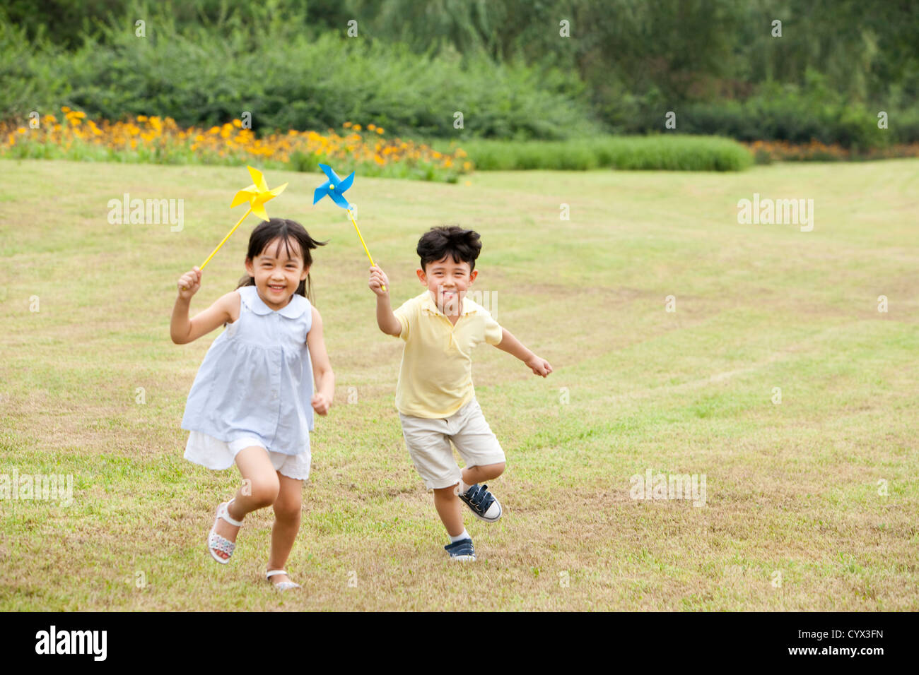 Excited children playing paper windmill Stock Photo - Alamy