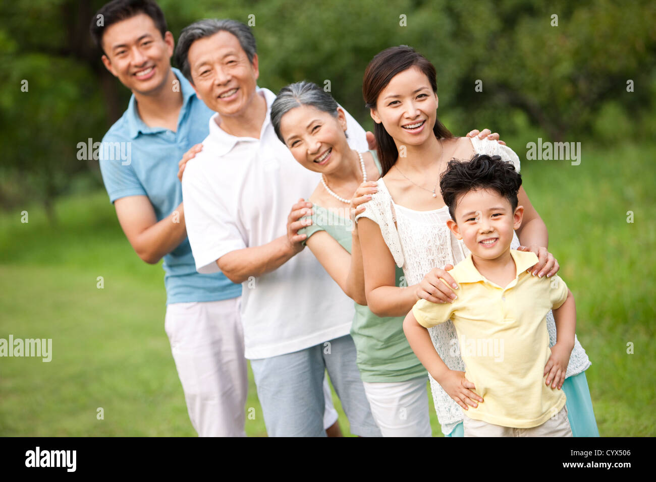 Happy family standing in a row outdoors Stock Photo - Alamy