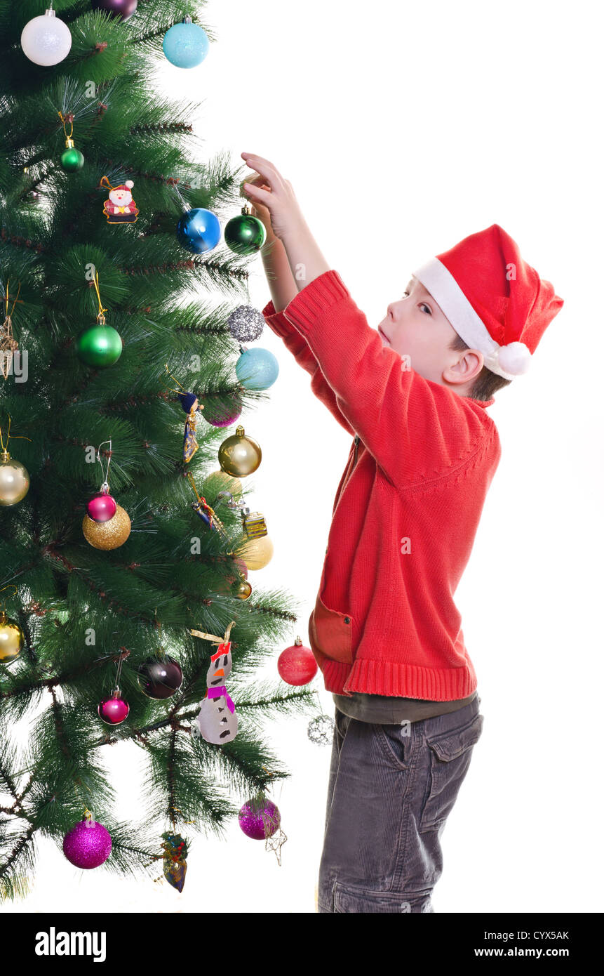 Young boy wearing santa hat decorating christmas tree, vertical shot ...