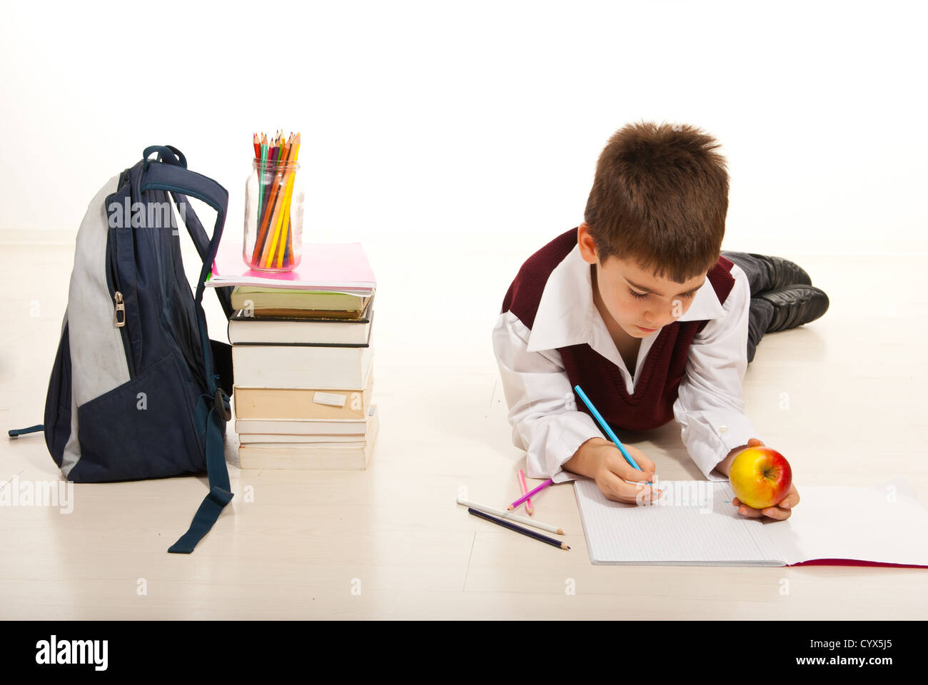 Schoolboy lying on floor home and doing homework Stock Photo - Alamy