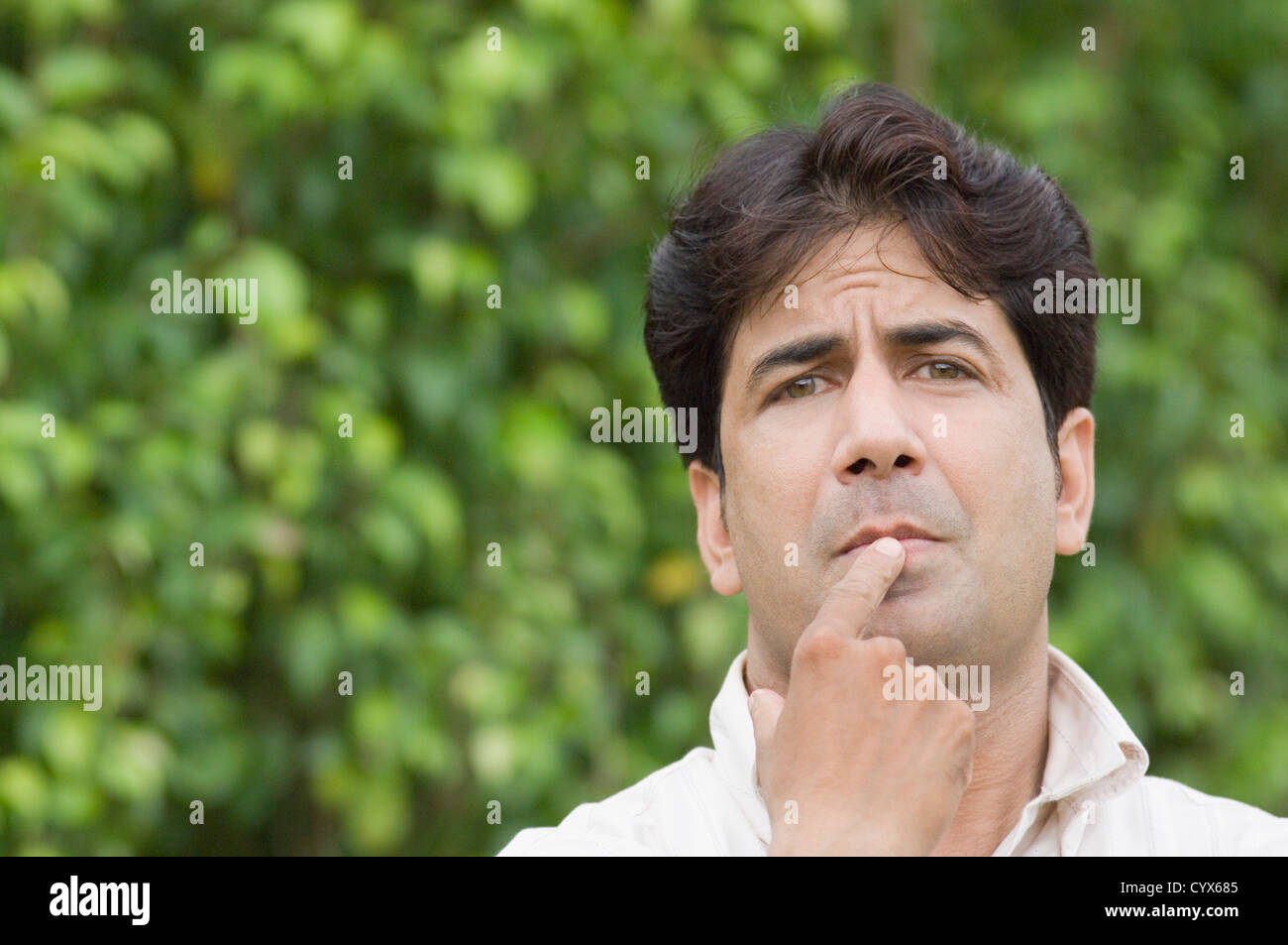Portrait of a man thinking in a park Stock Photo - Alamy