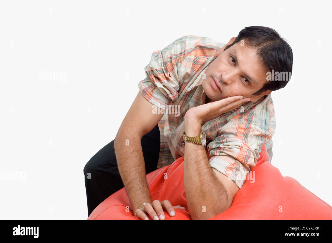 Man leaning on a bean bag and thinking Stock Photo - Alamy