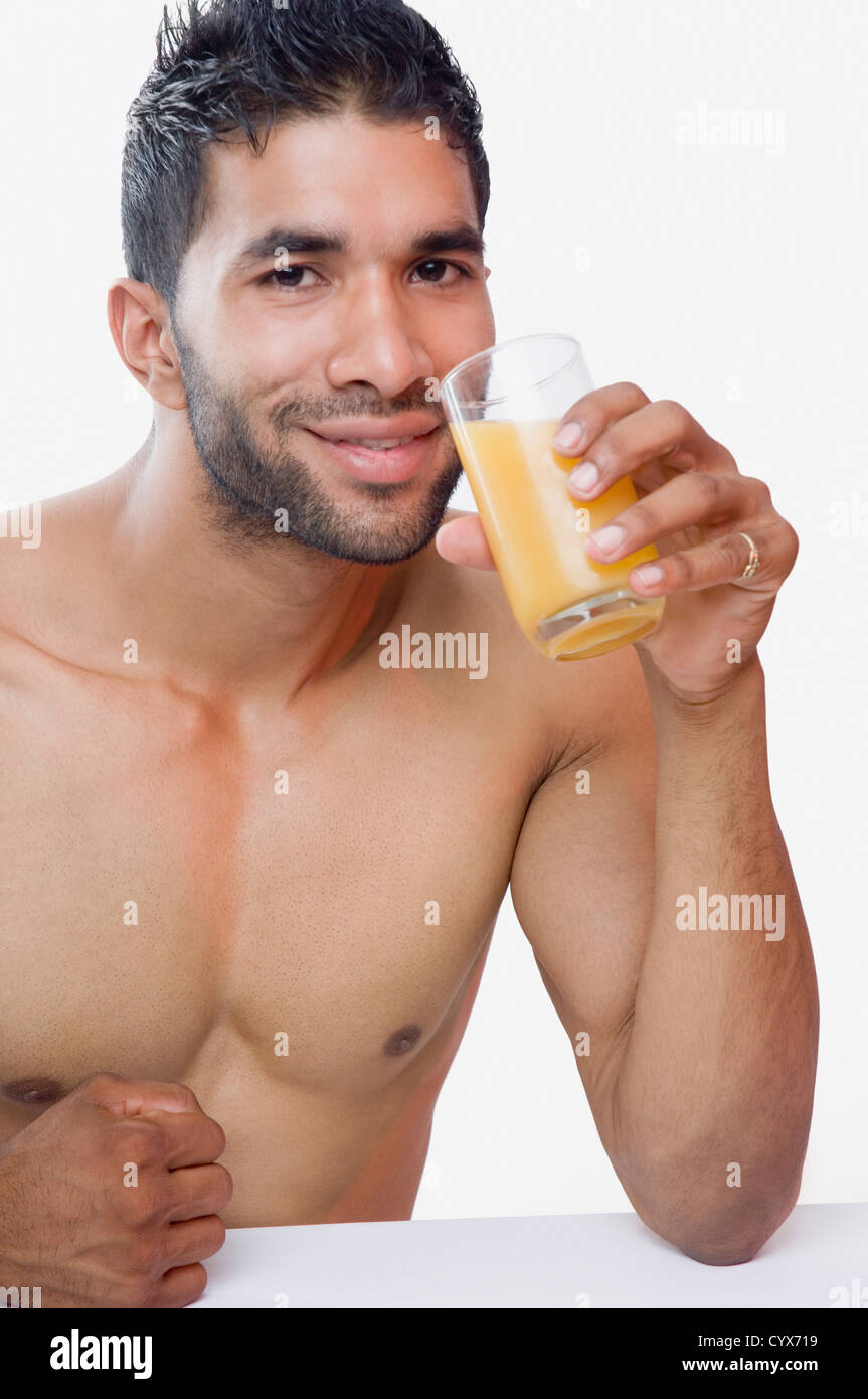 Portrait of a macho man drinking juice Stock Photo - Alamy