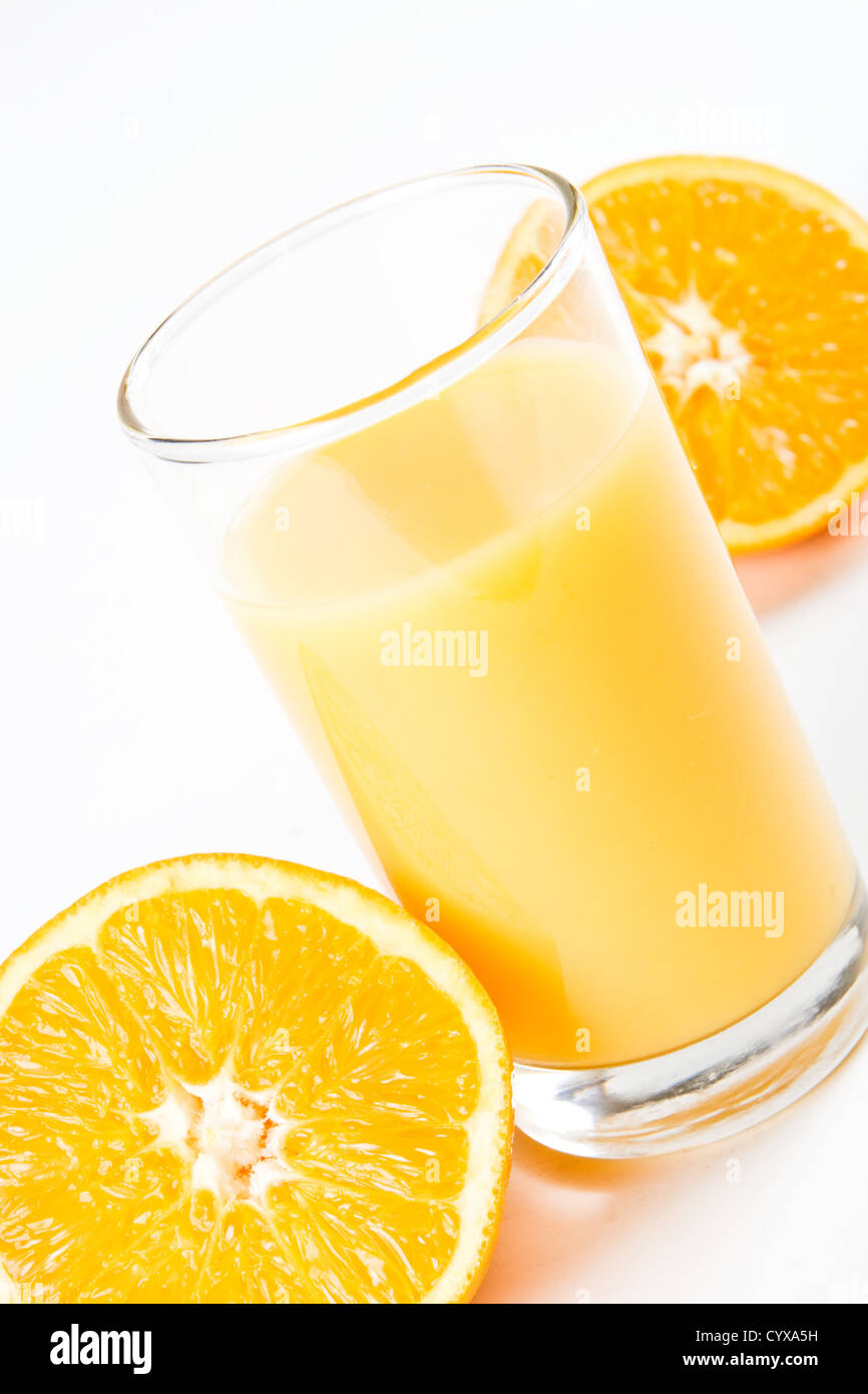 A glass of orange juice with two halves of orange Stock Photo - Alamy