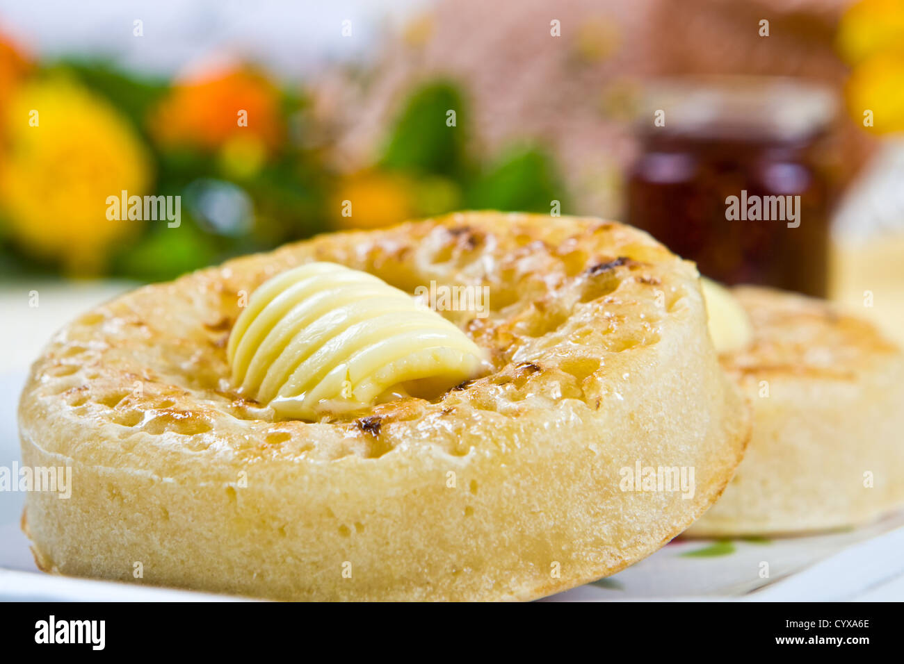 Freshly toasted crumpet with melting butter on a plate Stock Photo - Alamy