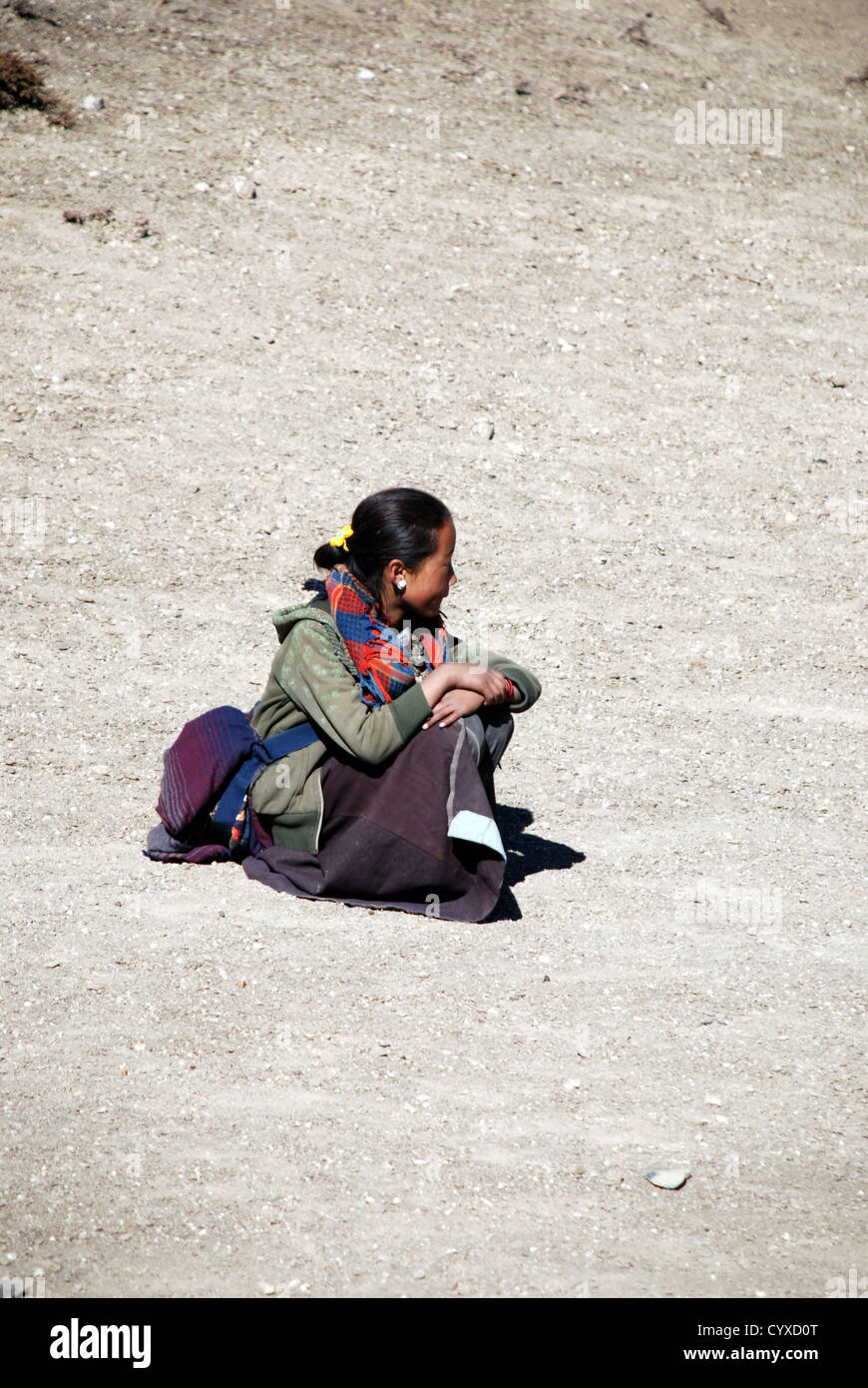 a young girl dressed in Tibetan clothing crossing the Shey La pass in ...