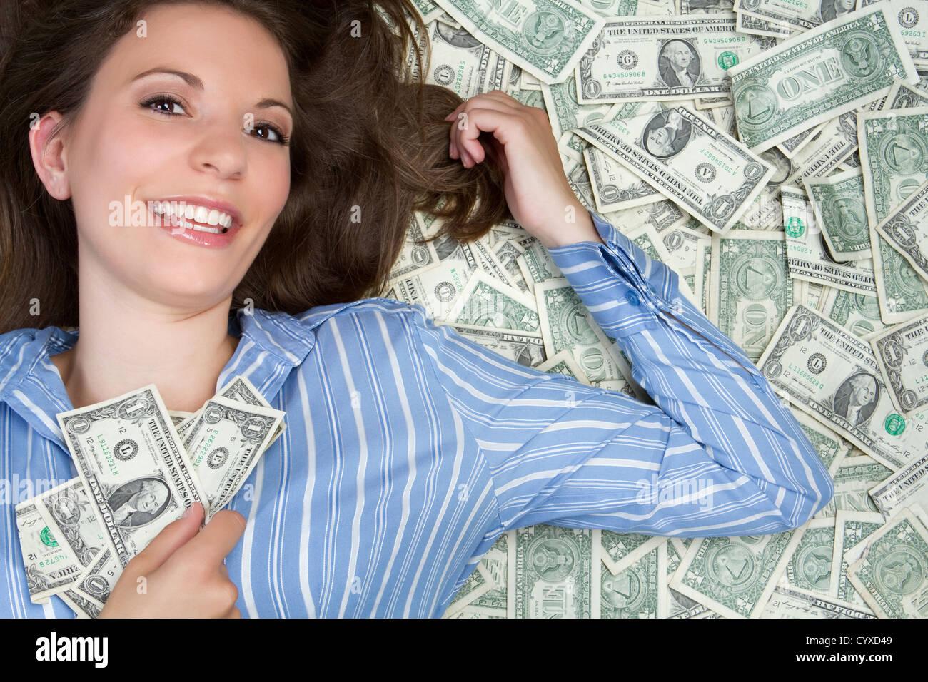 Beautiful woman laying in money Stock Photo - Alamy