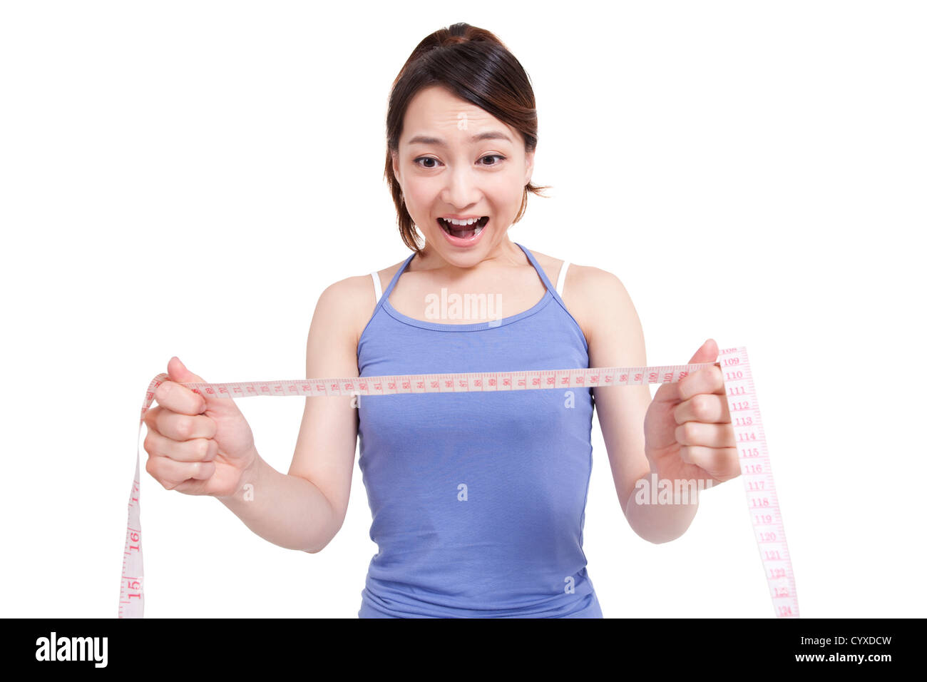 Surprised young woman checking tape measure Stock Photo - Alamy