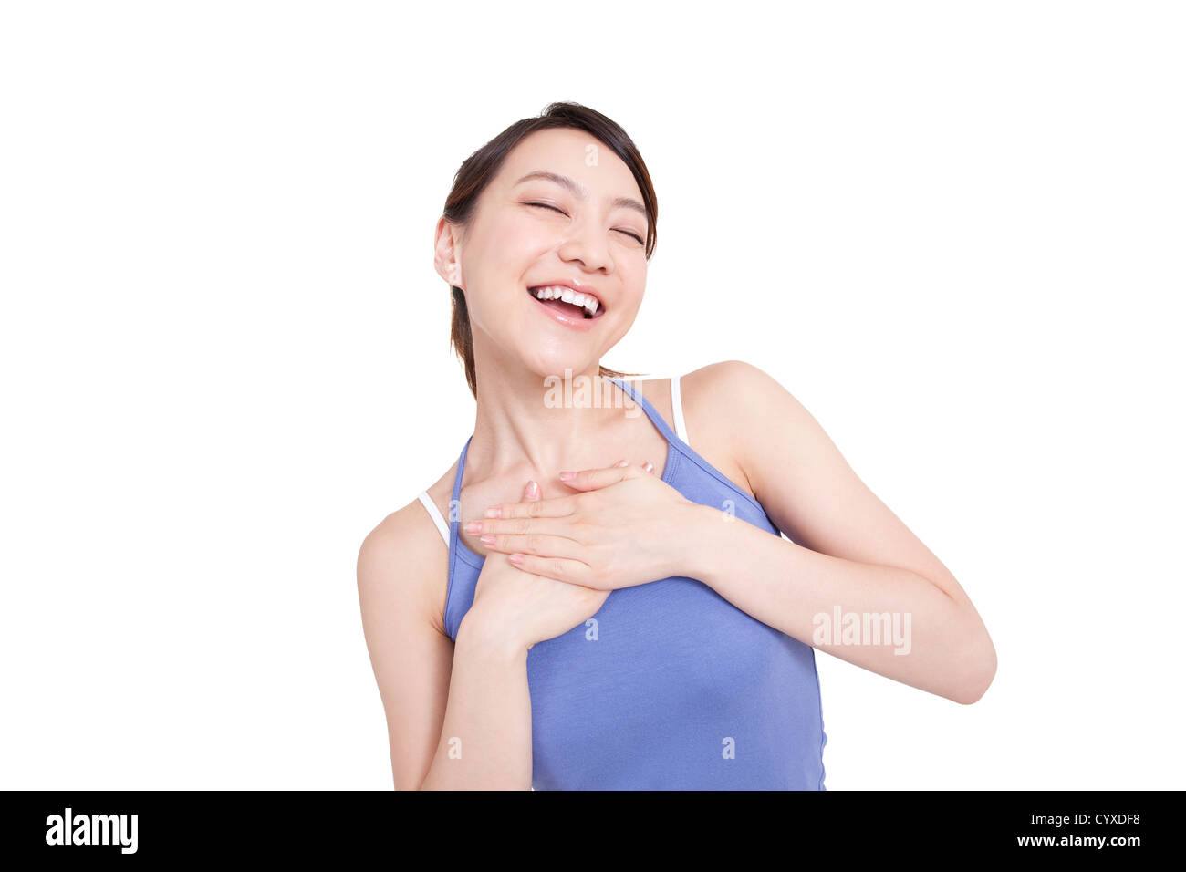 Joyful young woman putting hands on chest Stock Photo - Alamy