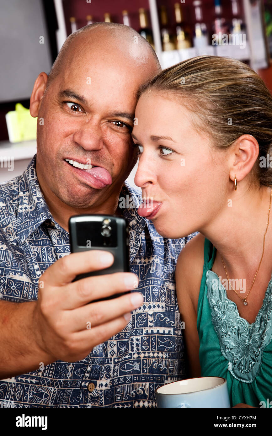 Attractive couple in a coffee house taking self-portrait with cell ...
