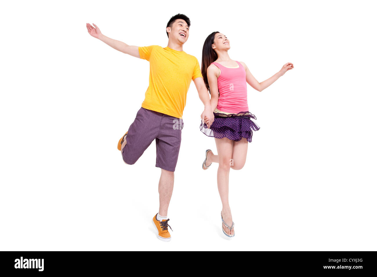 Excited young couple running hand in hand Stock Photo - Alamy