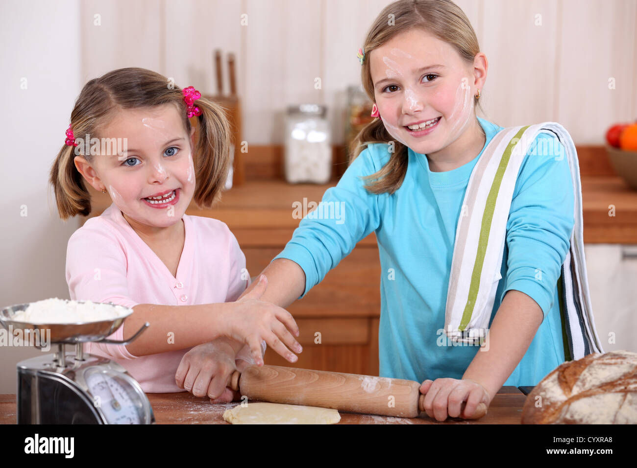 Young girls using a rolling pin Stock Photo - Alamy