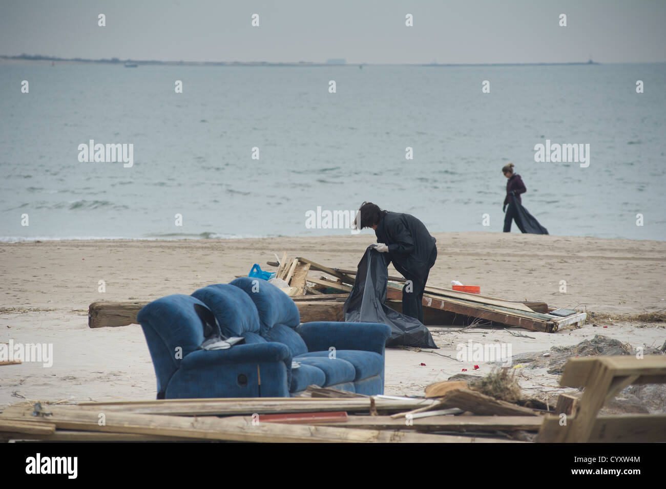 Volunteers clean up debris and sand deposited by Hurricane Sandy from ...