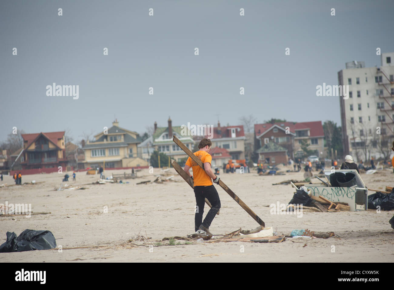 Volunteers clean up debris and sand deposited by Hurricane Sandy from ...