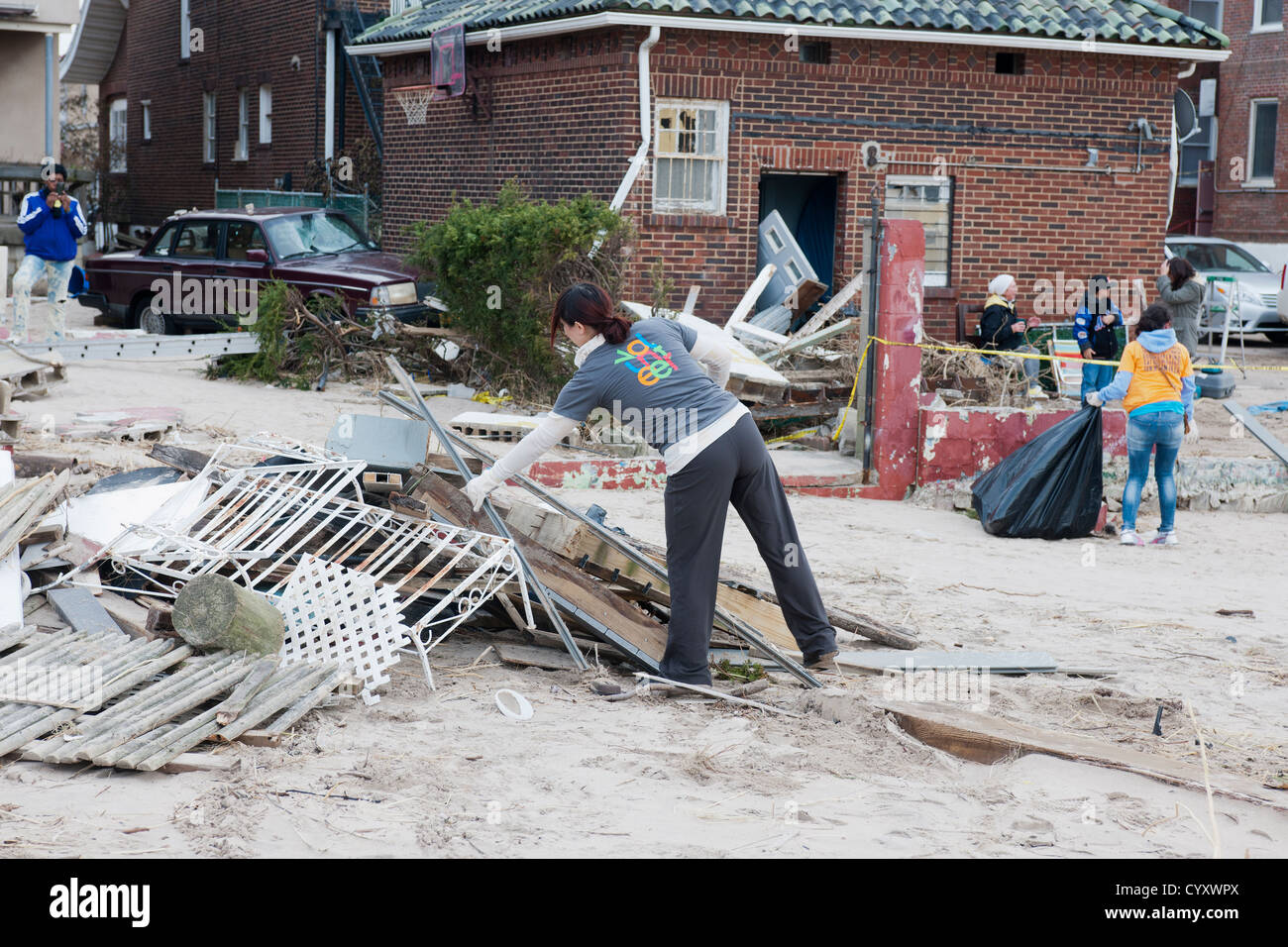 Volunteers clean up debris and sand deposited by Hurricane Sandy from ...