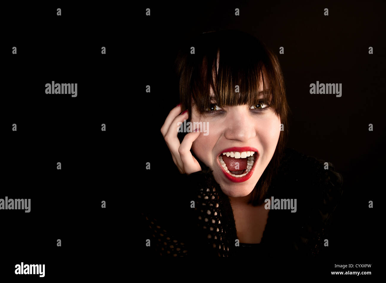 Young goth woman with hand to her face screaming in fear Stock Photo ...
