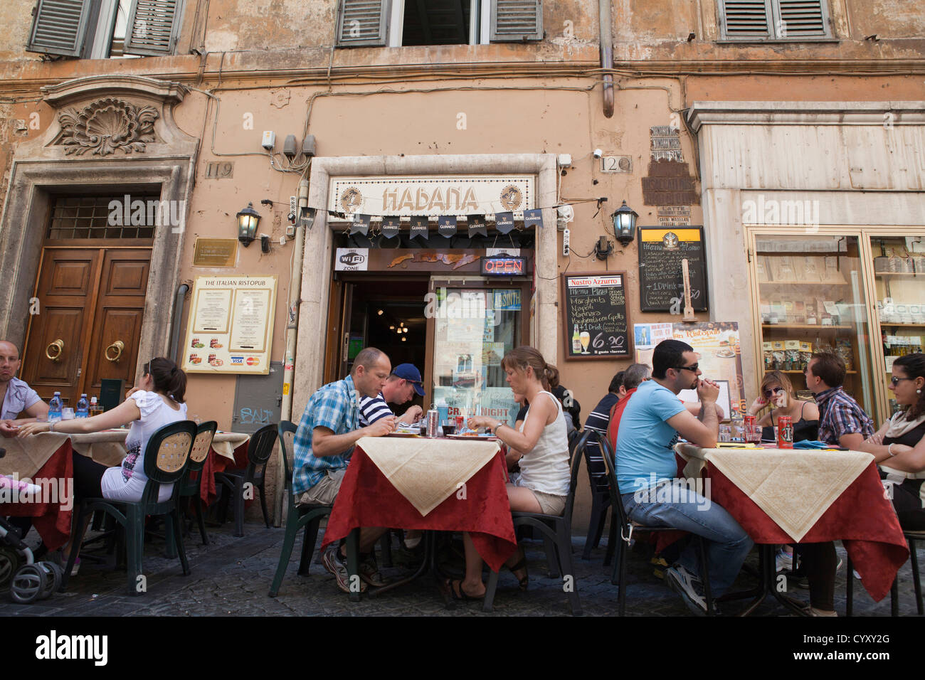Diners eating al at restaurant in back street hi-res stock photography ...