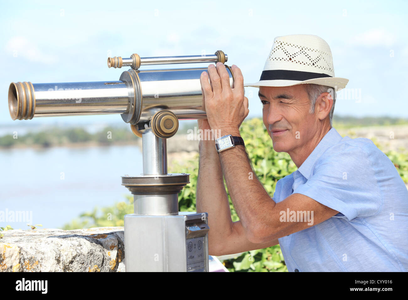 Man looking through telescope Stock Photo - Alamy