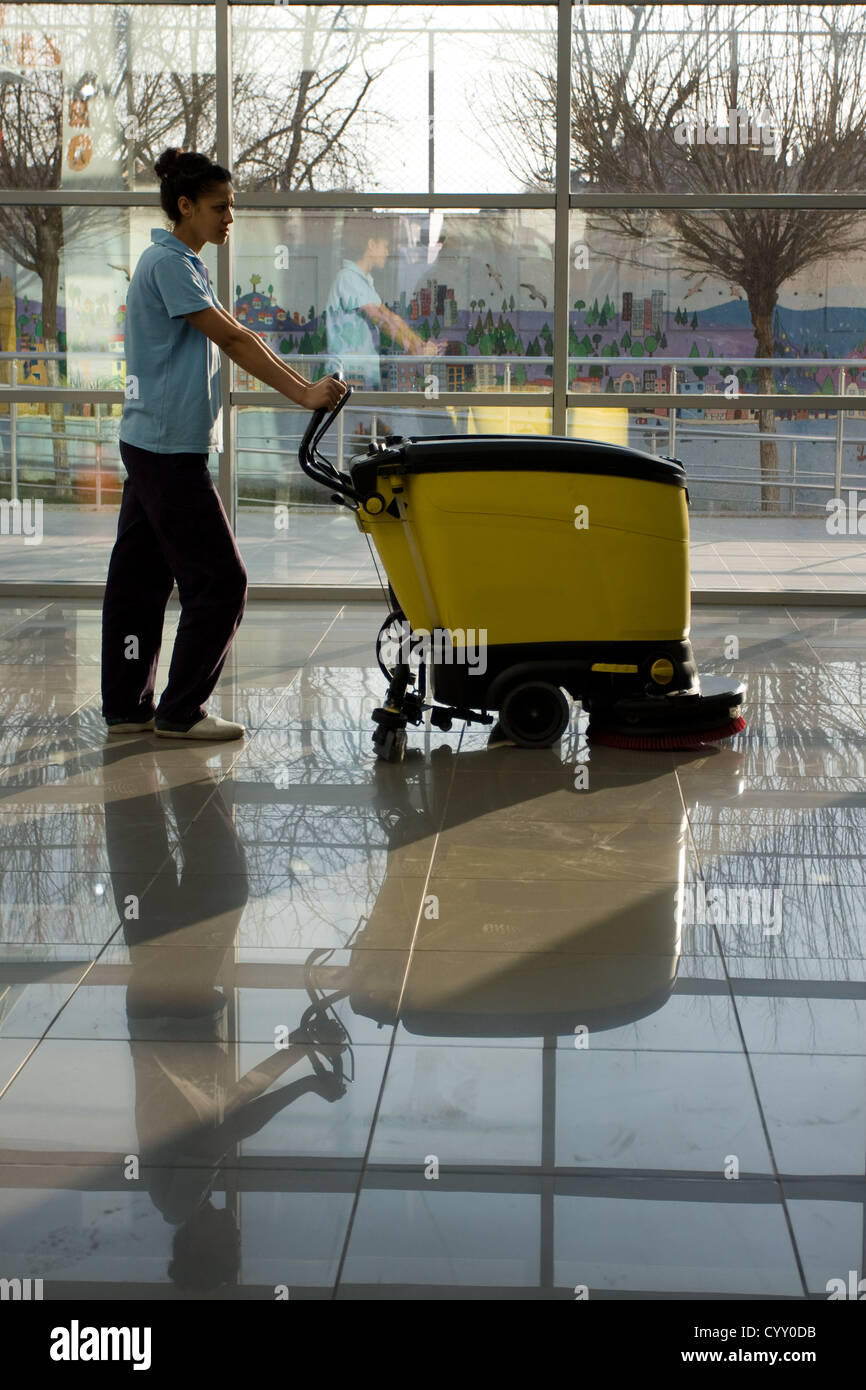 A worker is cleaning the floor with equipment Stock Photo - Alamy