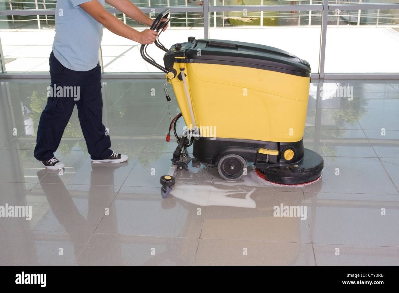A worker is cleaning the floor with equipment Stock Photo - Alamy