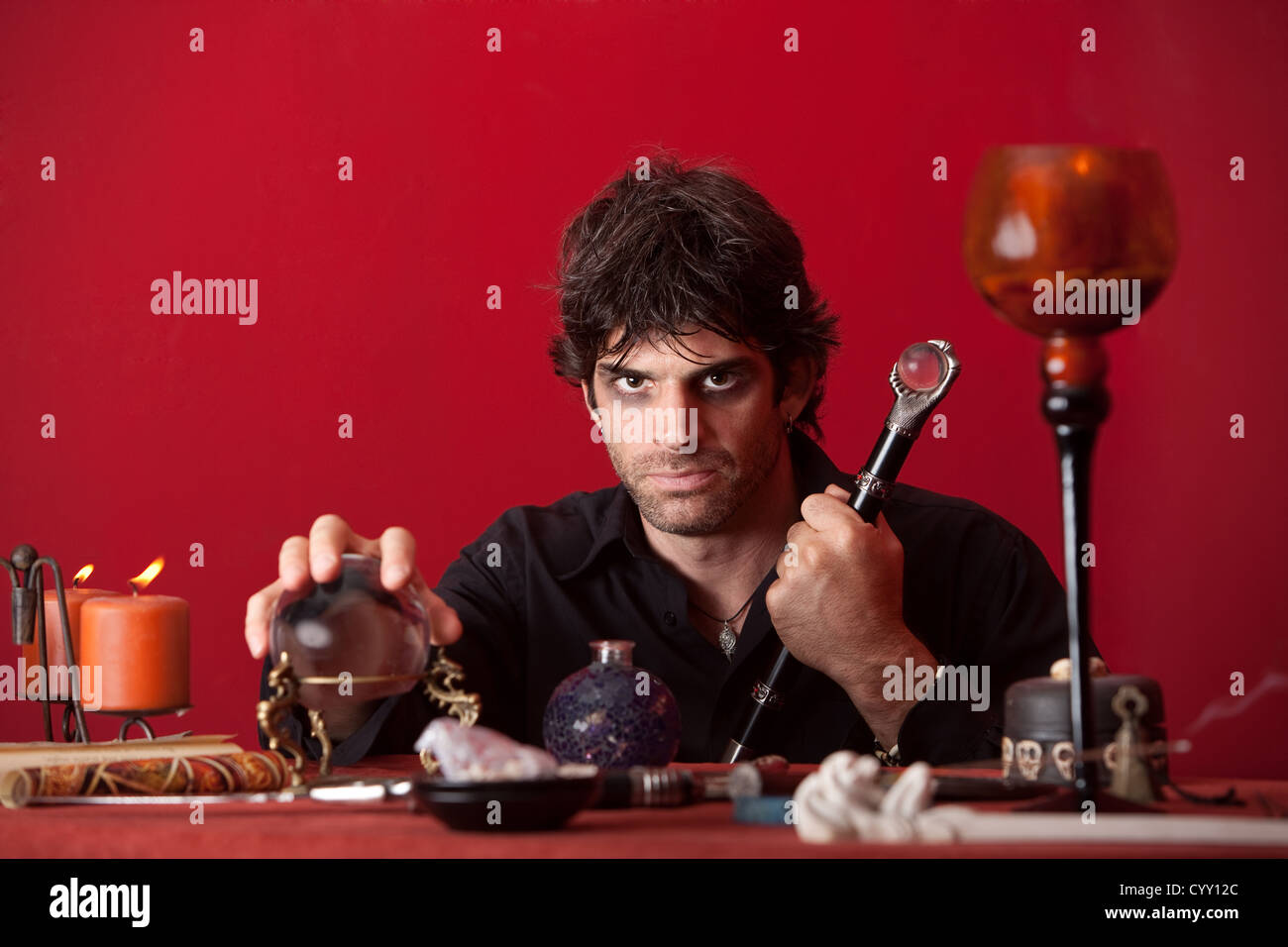 Evil man holds sceptre and crystal ball over red background Stock Photo ...