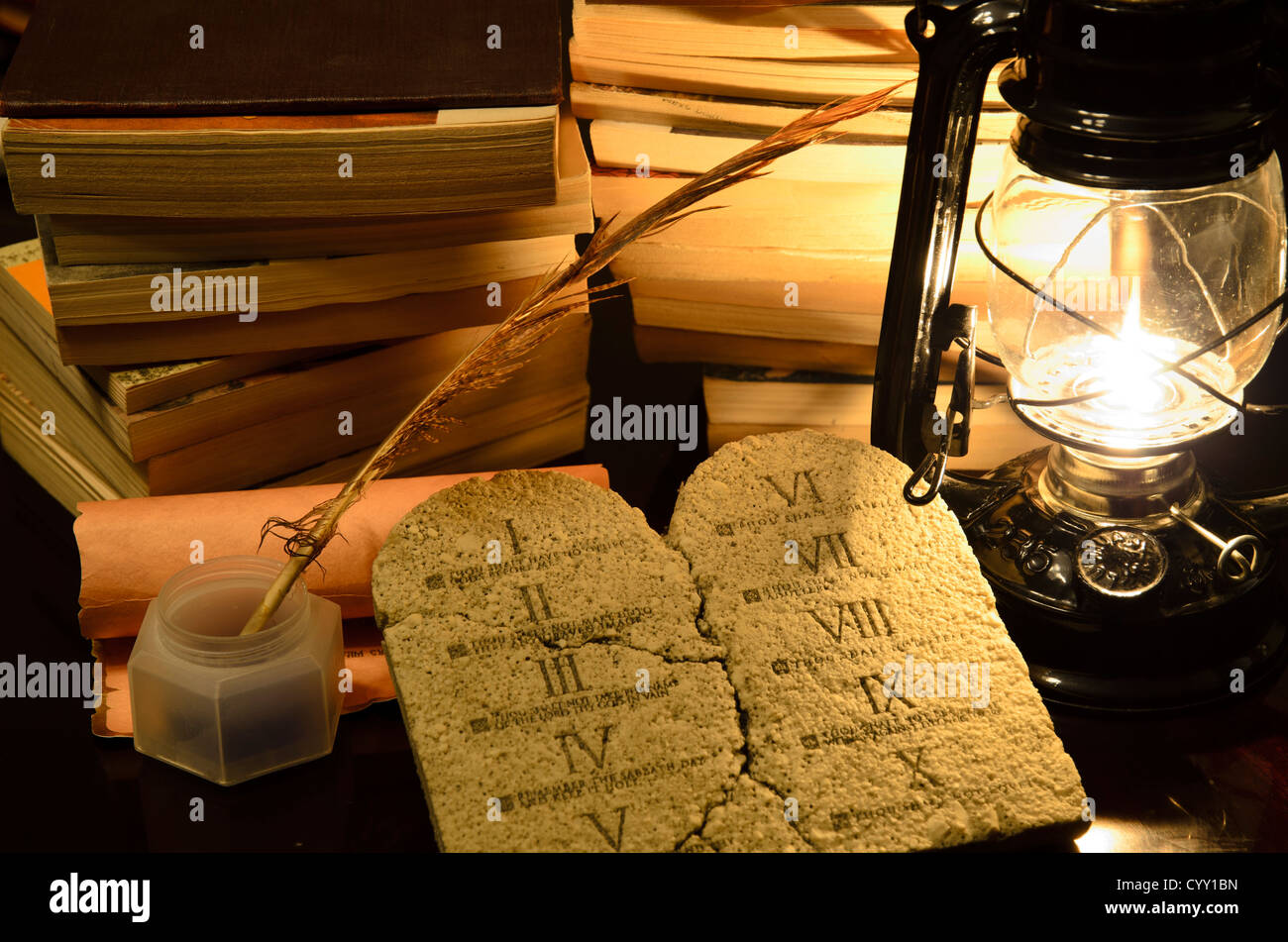 tables of the law surrunded by books in a lamp light Stock Photo - Alamy