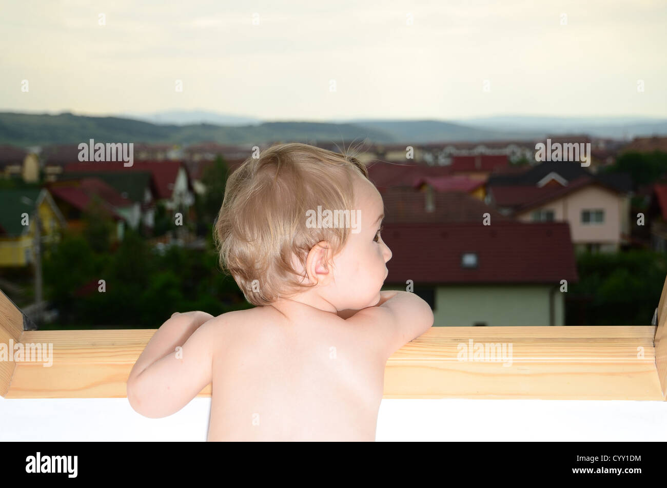 a cute baby looking at horizon through a roof window Stock Photo - Alamy