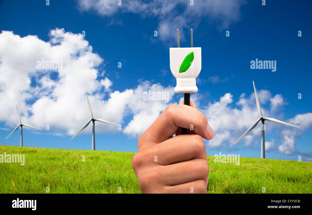 Hand hold eco power plug and Wind turbines on blue sky Stock Photo - Alamy