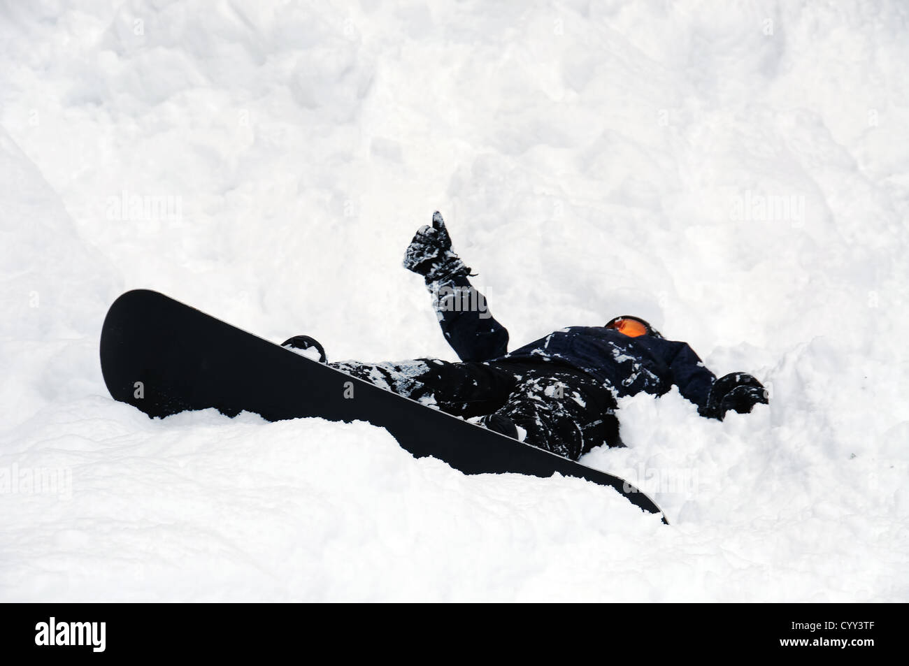 Snowboarder lying in the snow with the thumb up Stock Photo - Alamy