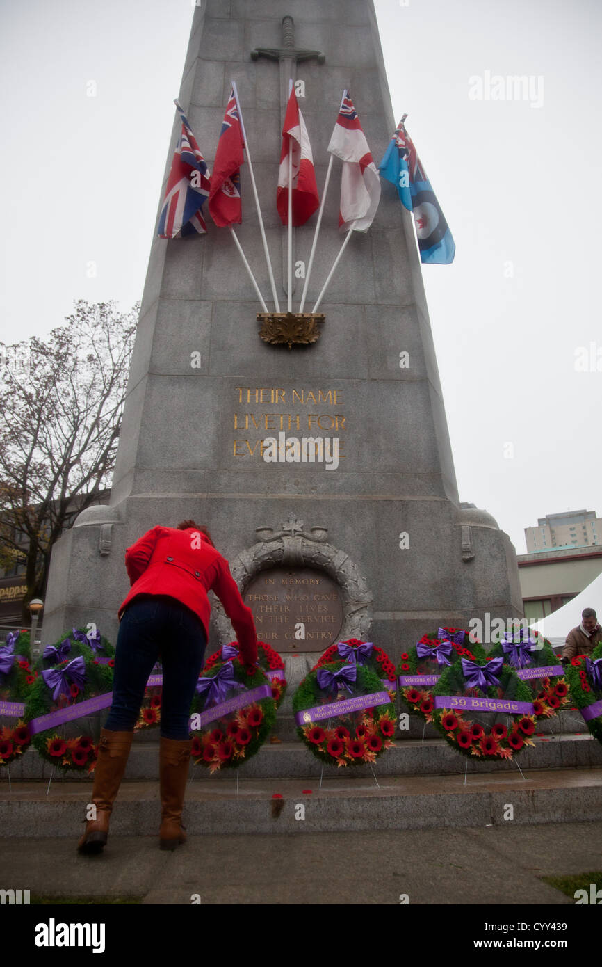 A woman leaves her poppy on a wreath on Remembrance Day at the Cenotaph ...